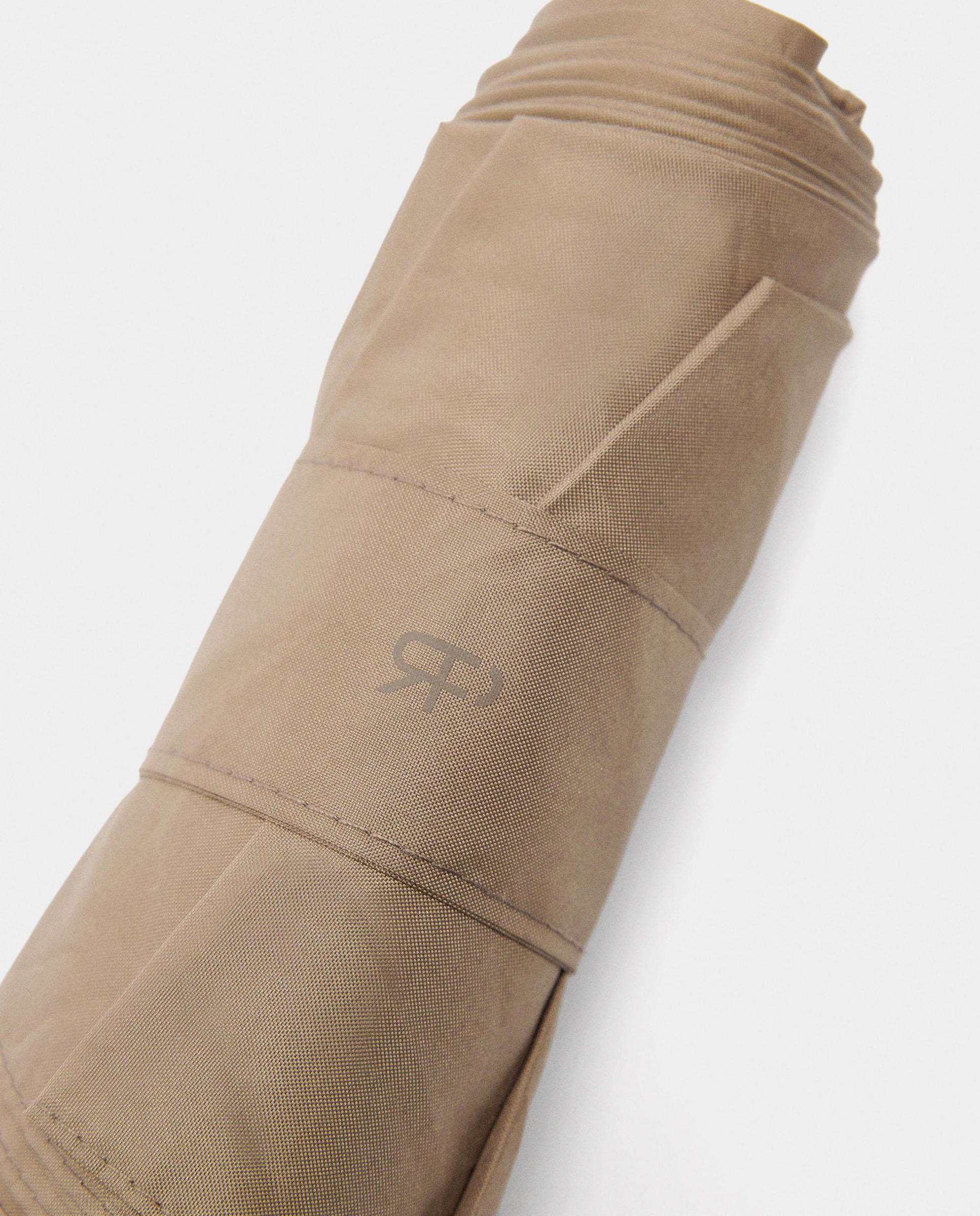 Largo impermeable mediano en liso Beige Parfois · El Corte Inglés